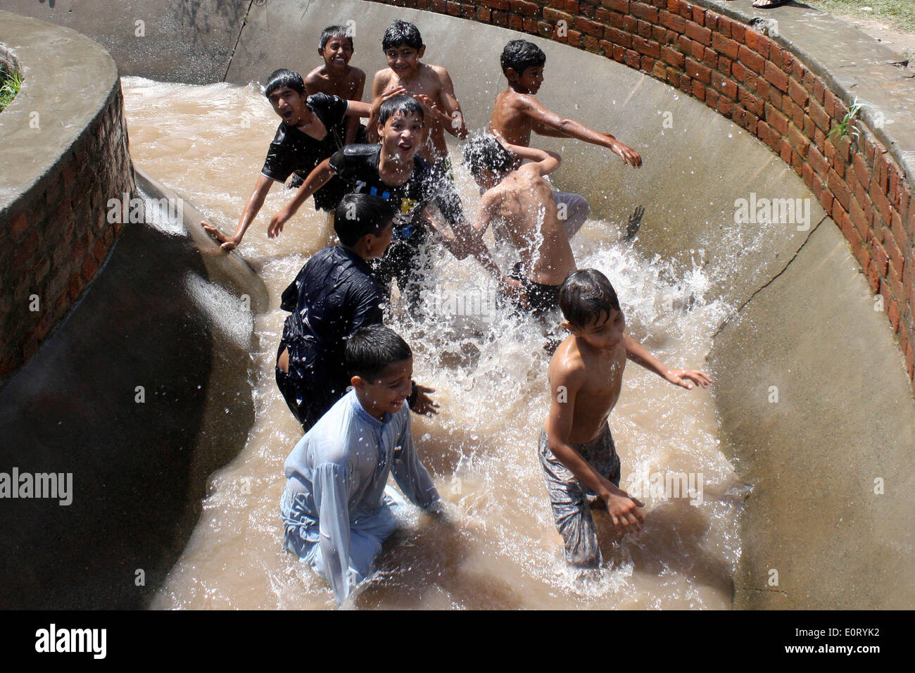 Lahore, Pakistan. 19th May, 2014. Pakistani boys play in water during a ...