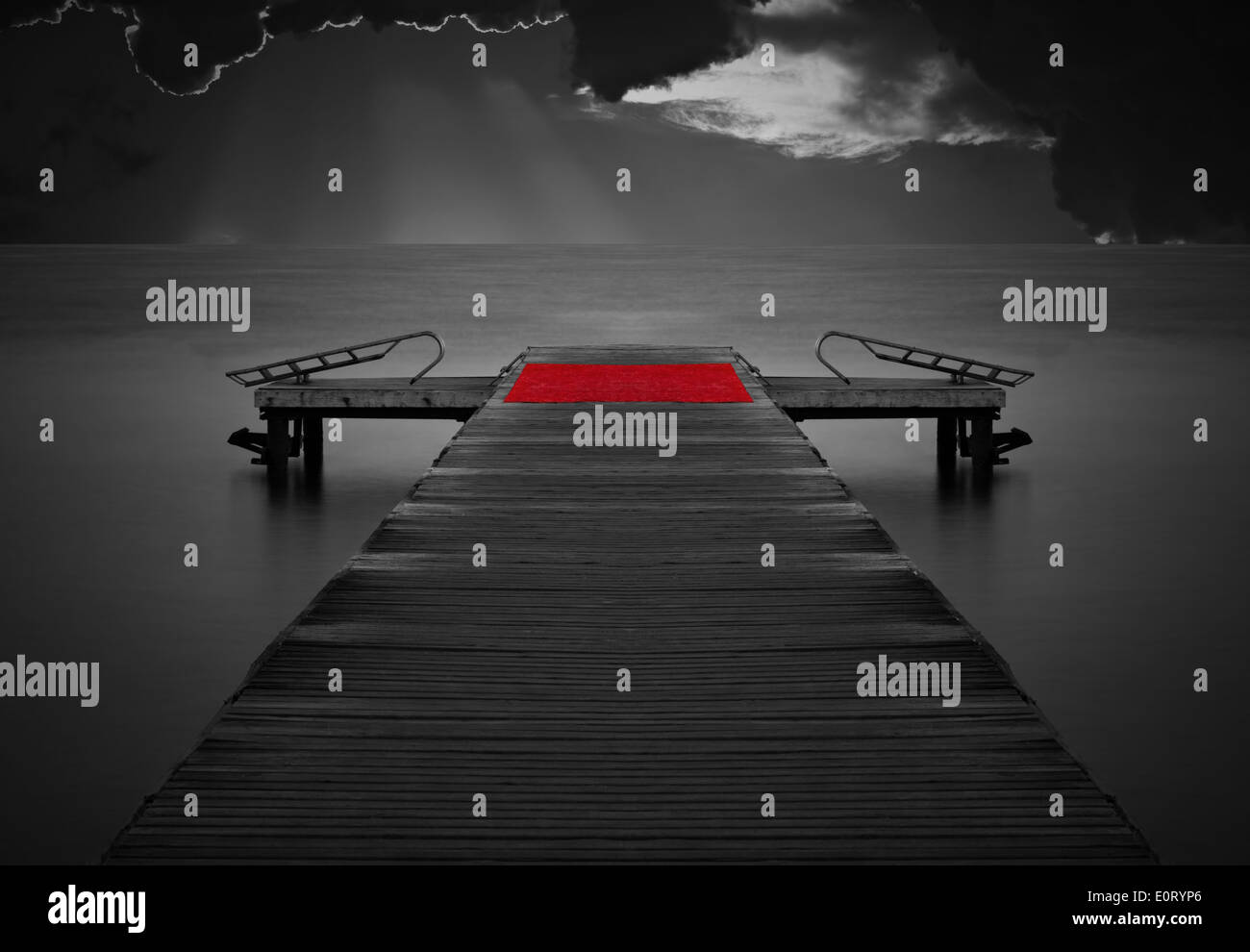 Moody empty jetty with red mat against stormy clouds Stock Photo - Alamy