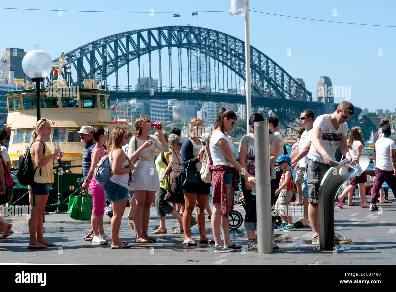 Tourist queue for fresh drinking water in the searing heat of summer ...