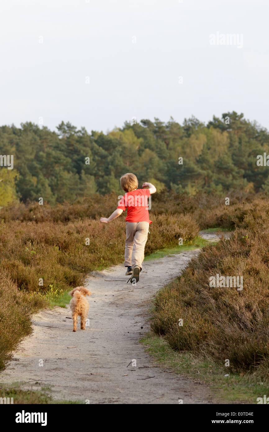young boy running with his dog Stock Photo - Alamy