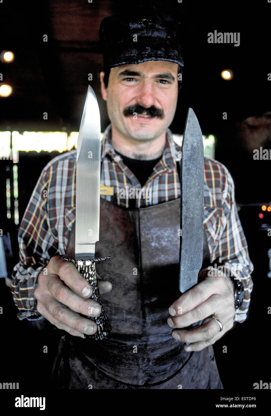 A blacksmith shows off the shiny knife he has forged from raw metal ...