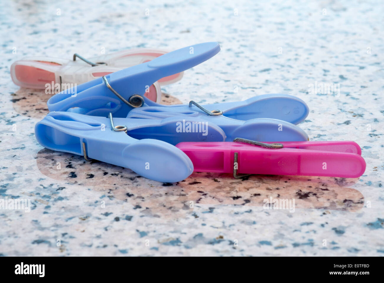 Coloured cloths pegs on a marble topped table Stock Photo - Alamy