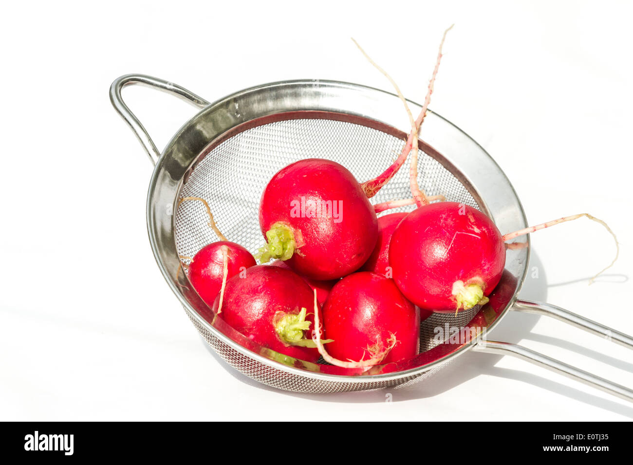 fresh clean red radishes in a strainer over a white background Stock ...