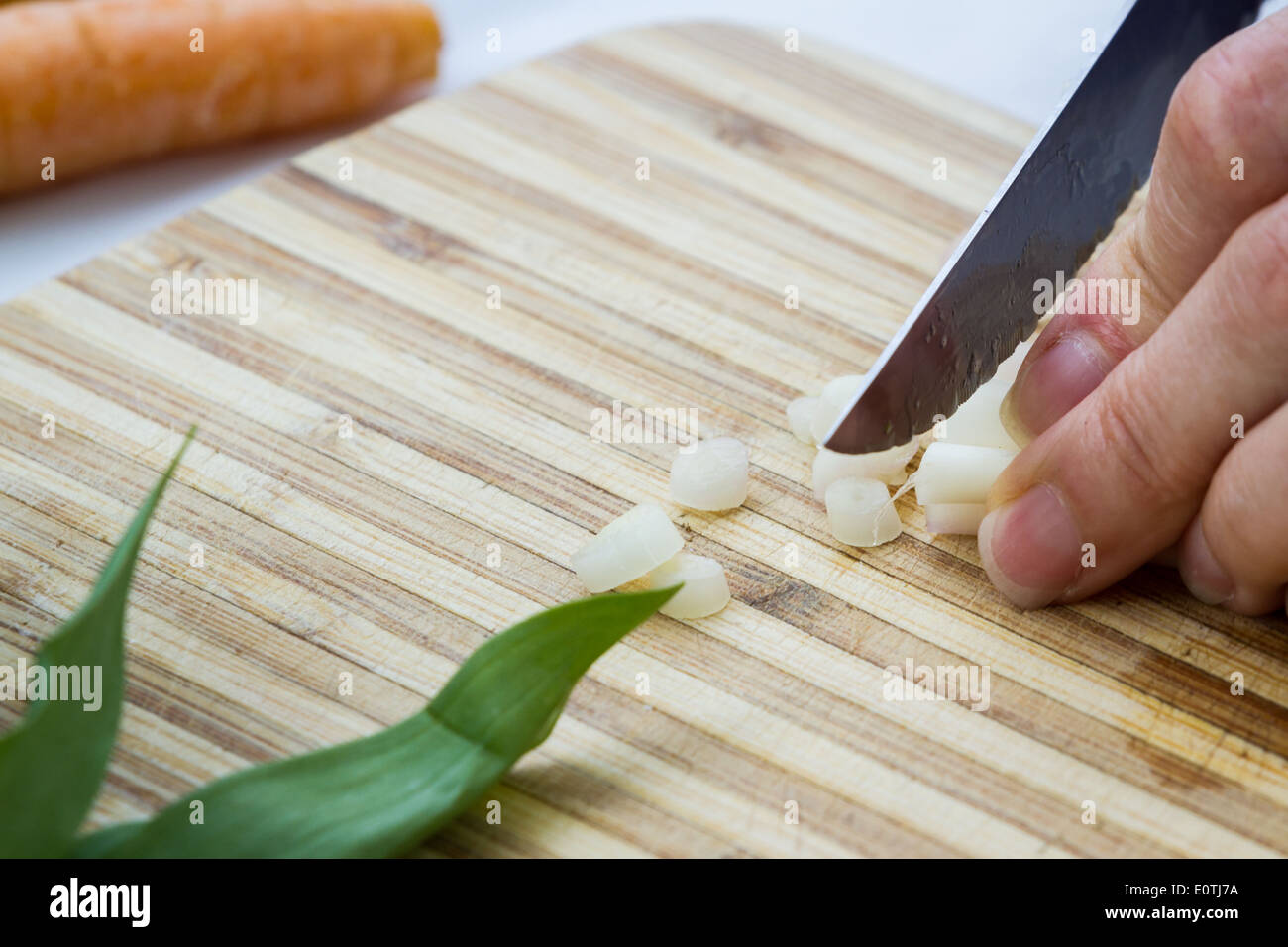 closeup of fingers slicing with a small knife fresh clean leeks Stock ...