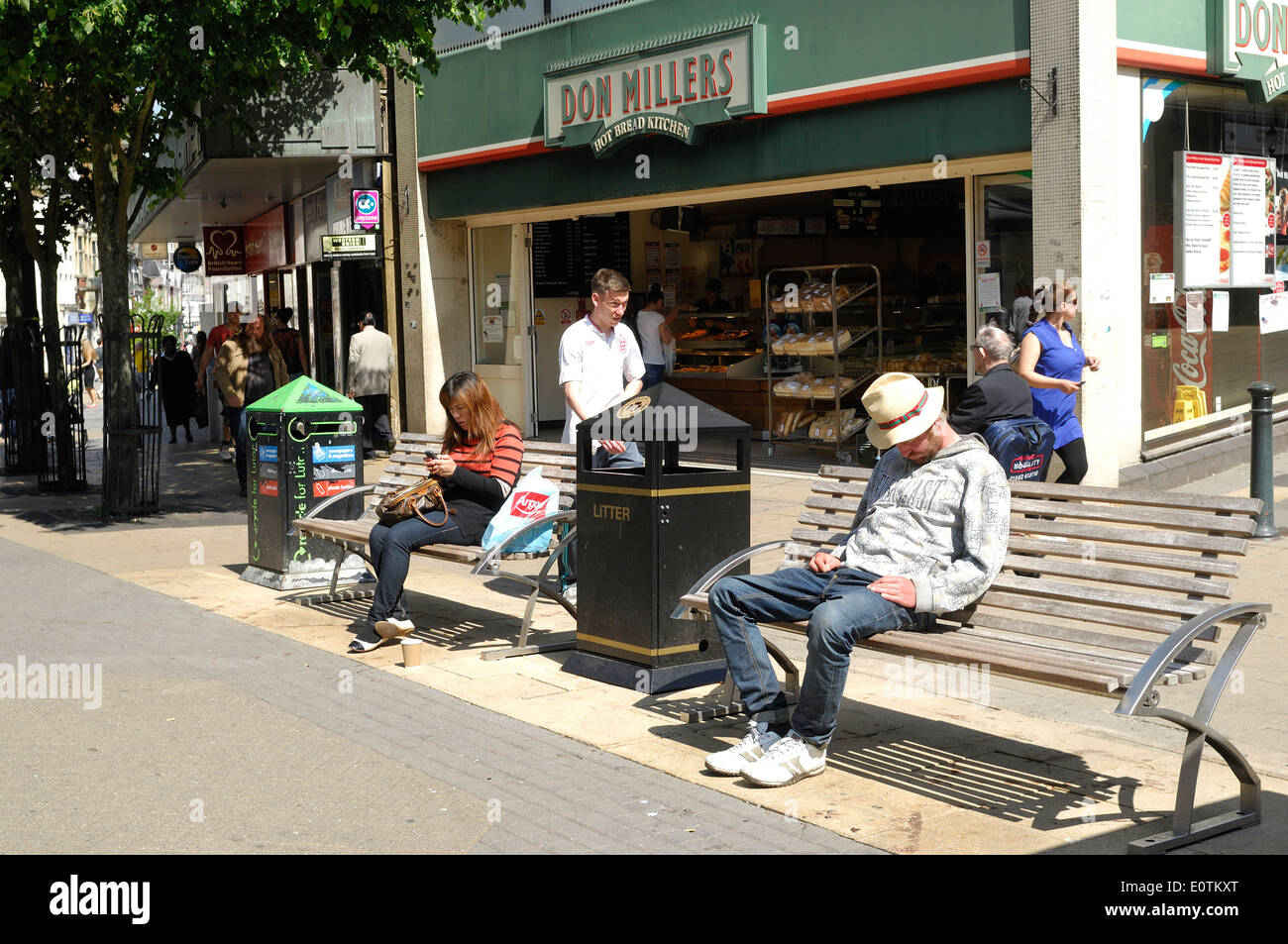 man snoozing on bench in Luton town centre Stock Photo - Alamy