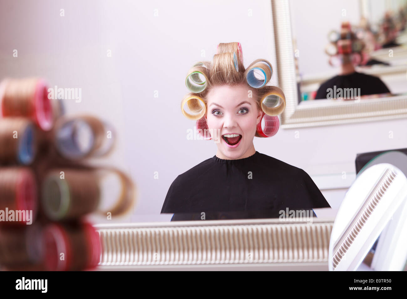 Portrait of funny happy woman in beauty salon. Cheerful blond girl with ...