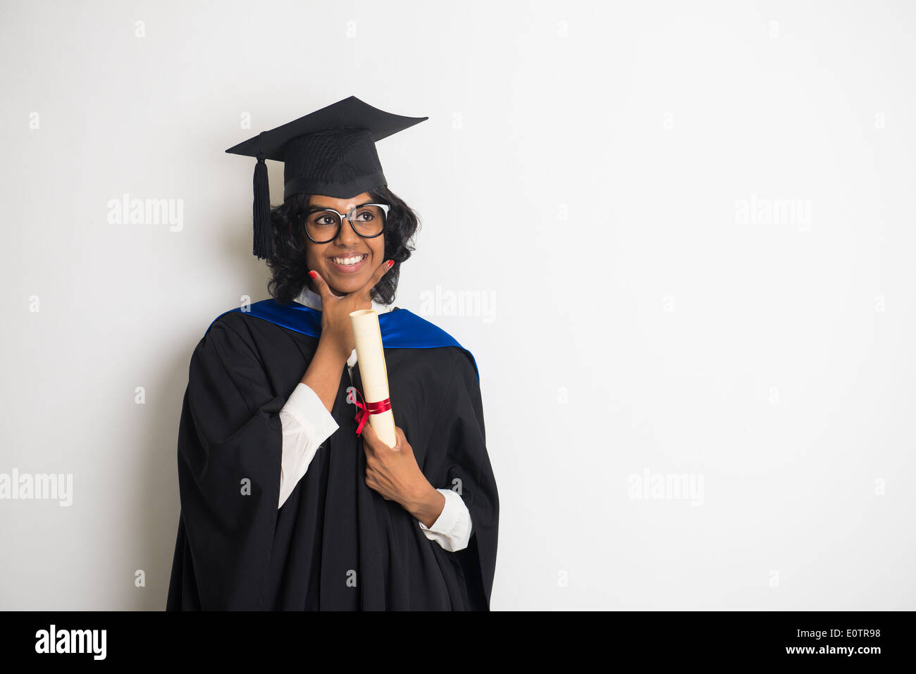 indian female graduate thinking with grey background Stock Photo - Alamy