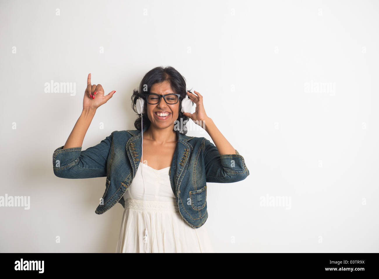 casual indian female listening to music with grey background Stock ...