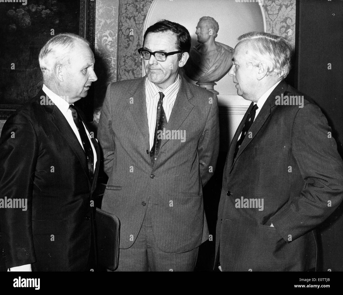 Gathering three colleagues discussing hi-res stock photography and ...