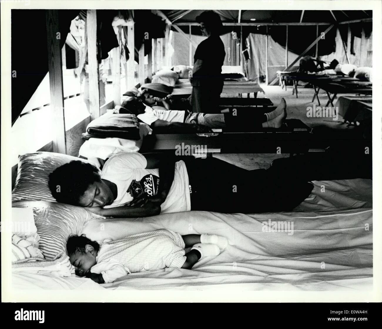 Apr. 04, 1962 - A father and baby sleep in their temporary canvas home ...