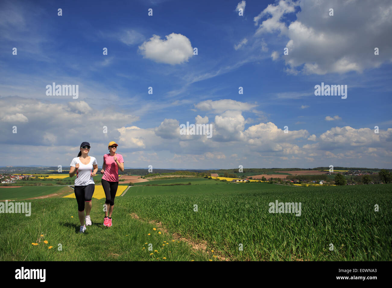 two women jogging through fields at the springtime Stock Photo - Alamy