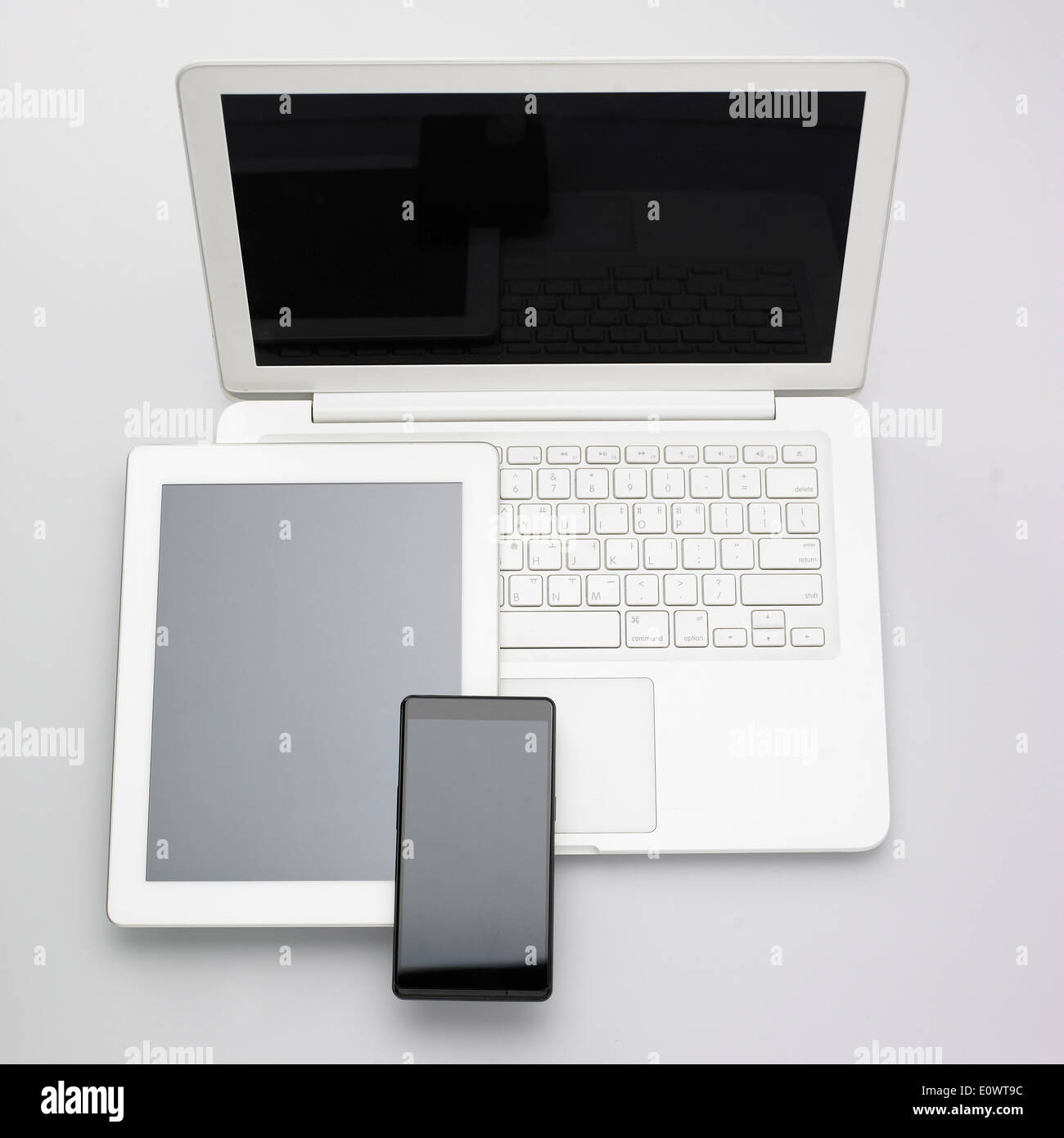 a smart phone and a tablet next to a laptop Stock Photo - Alamy