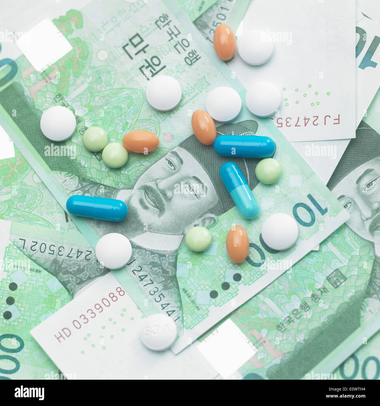 capsules and pills on a pile of money Stock Photo - Alamy