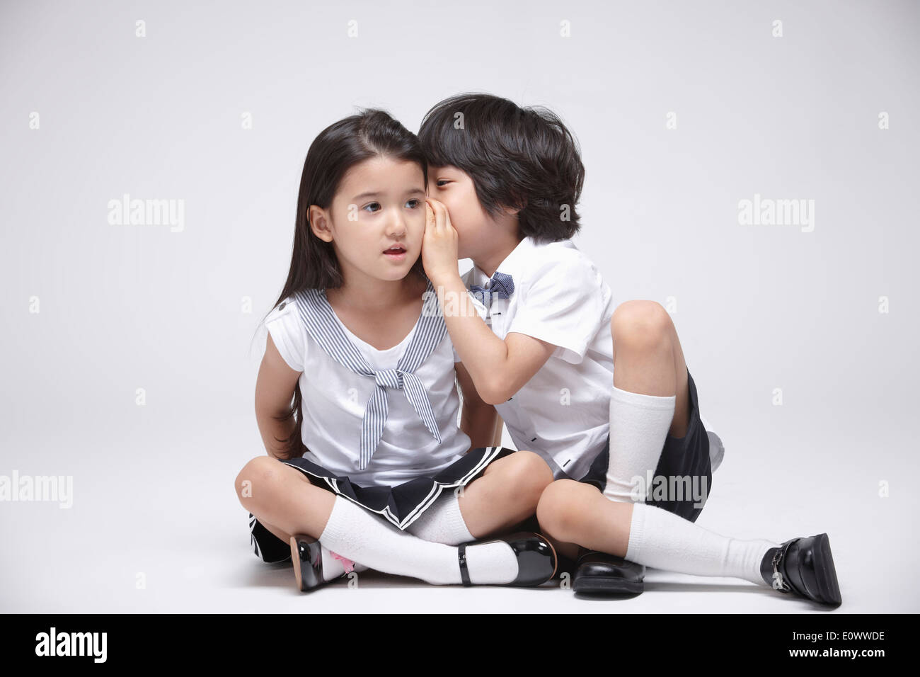 a boy and a girl sitting next to each other Stock Photo - Alamy