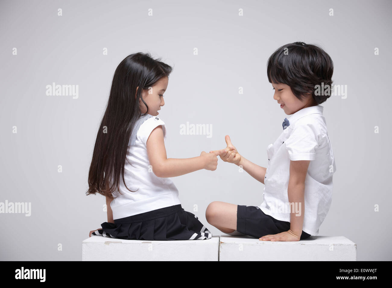 a boy and a girl sitting next to each other Stock Photo - Alamy