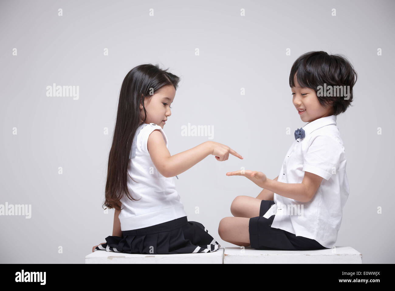a boy and a girl sitting next to each other Stock Photo - Alamy
