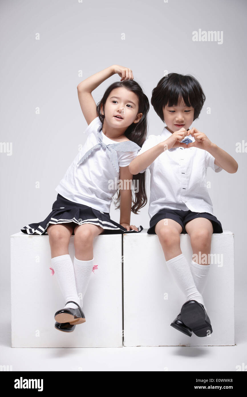 a boy and a girl sitting next to each other Stock Photo - Alamy