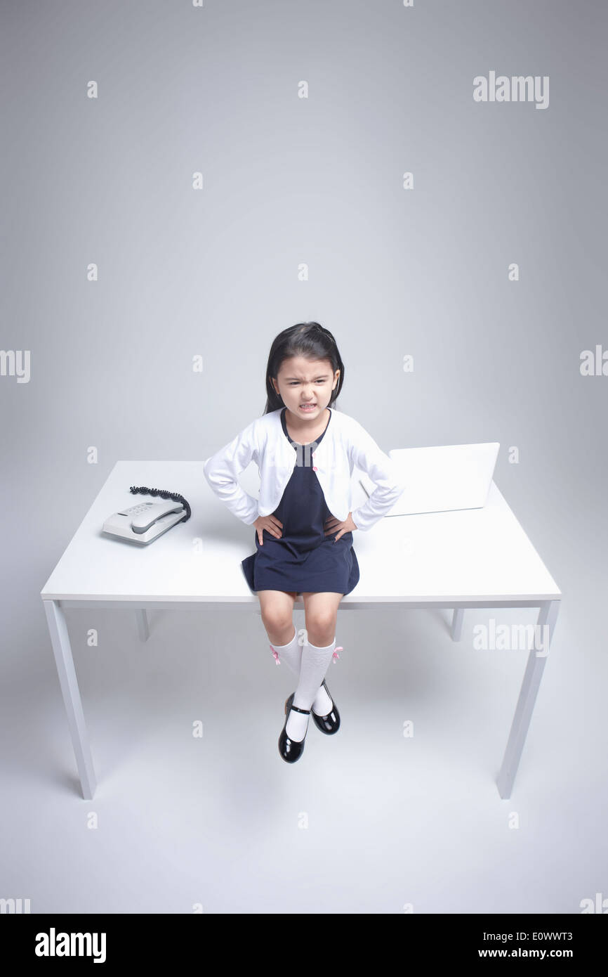 a girl sitting on a table Stock Photo - Alamy