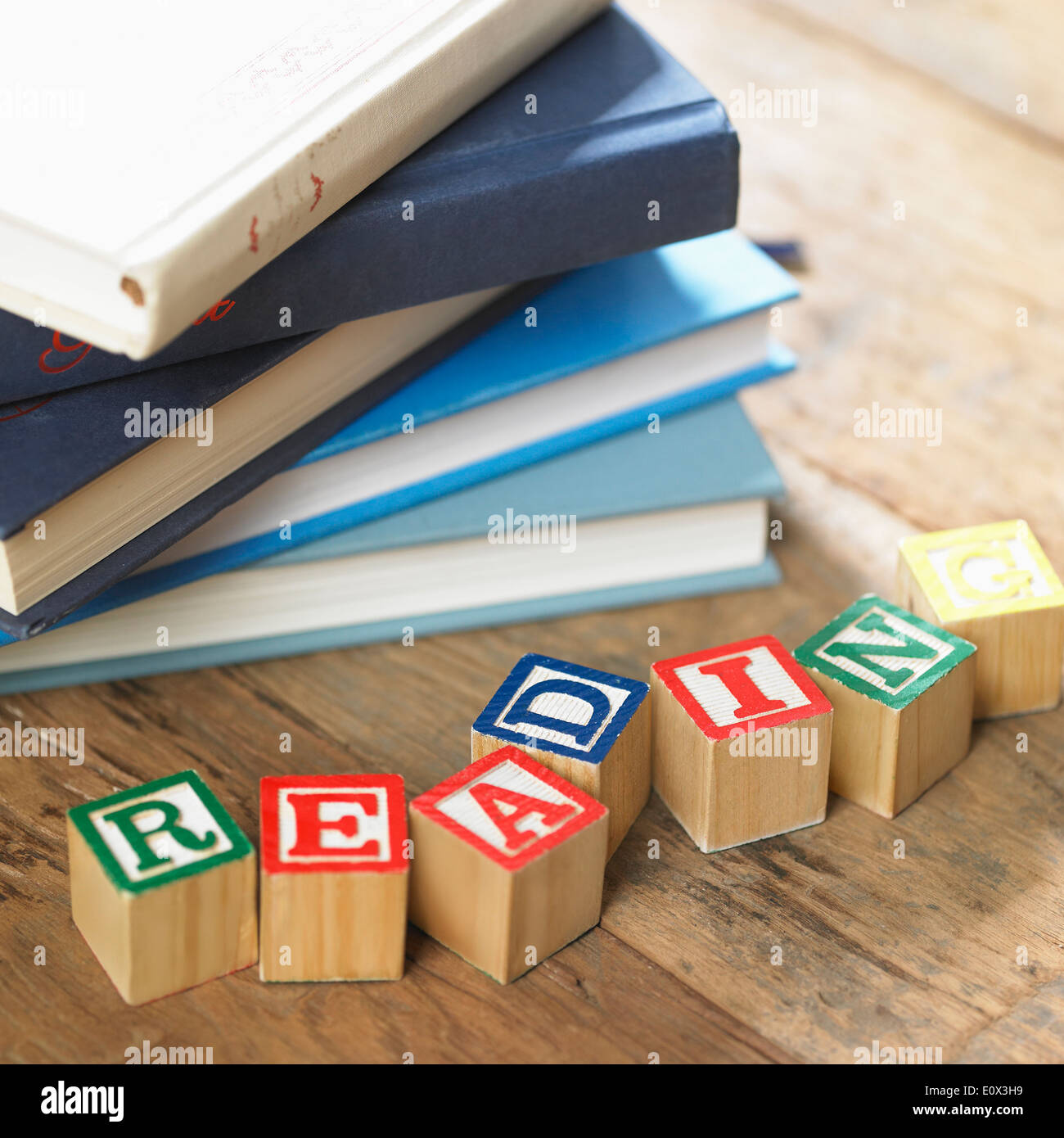 a pile of books next to cubes spelling reading Stock Photo - Alamy