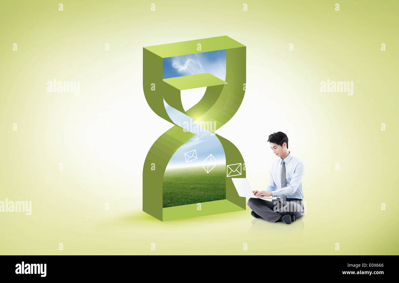 a business man posing next to a time glass Stock Photo - Alamy