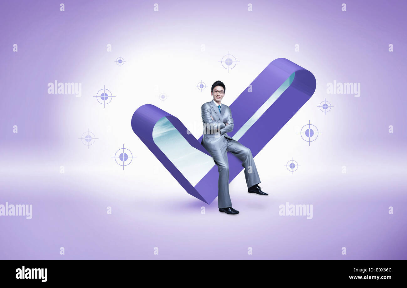 a business man posing next to a check mark Stock Photo - Alamy