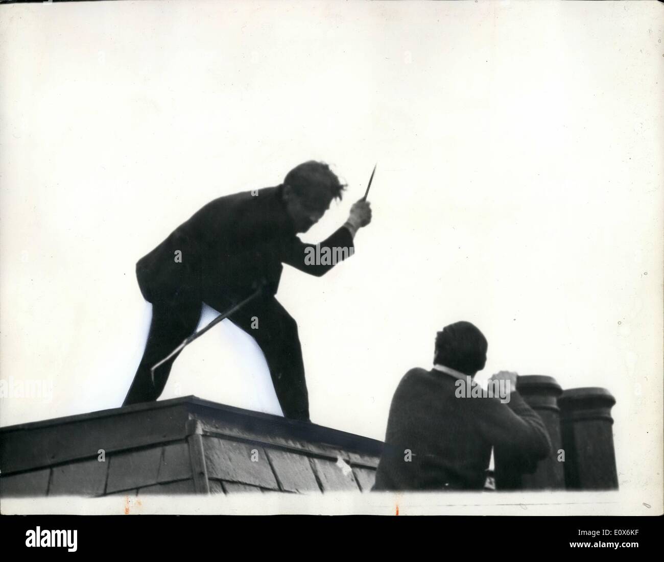 Aug. 08, 1965 - Man with Knife in Rooftop Siege: A man armed with a ...