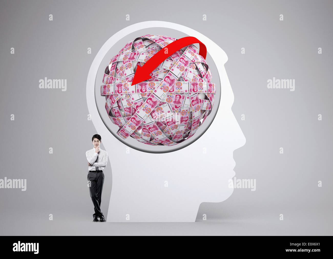 a business man next to a ball of money Stock Photo - Alamy