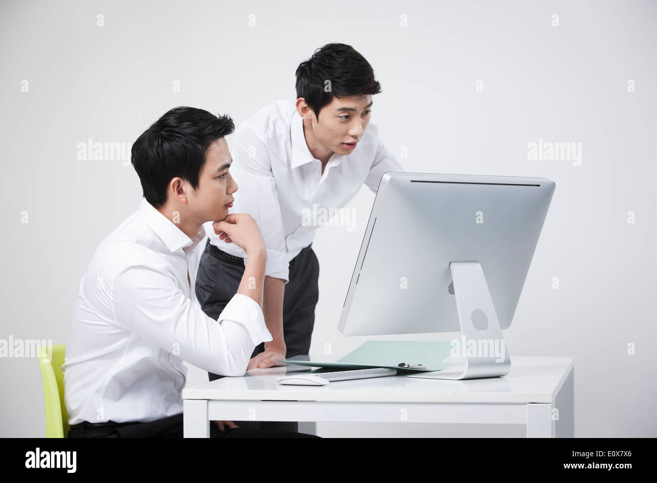 two business men looking at a computer screen Stock Photo - Alamy