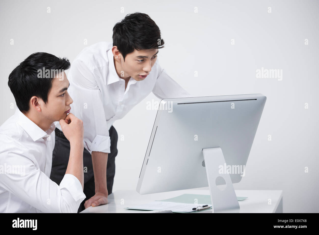 two business men looking at a computer screen Stock Photo - Alamy