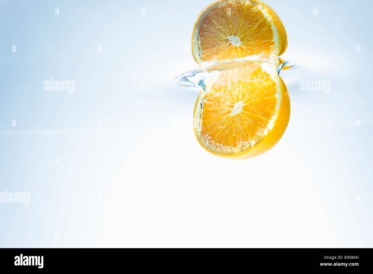an orange half falling in water Stock Photo - Alamy