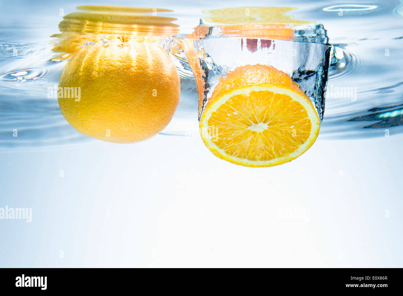 two orange halves falling in water Stock Photo - Alamy