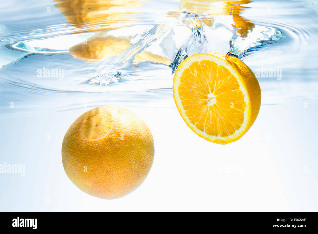 two orange halves falling in water Stock Photo - Alamy