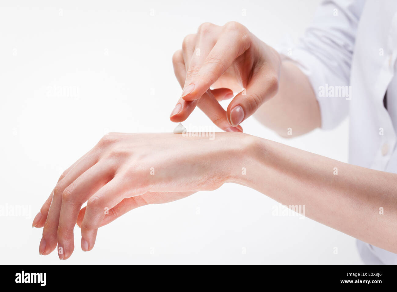 a woman rubbing lotion on her hands Stock Photo - Alamy