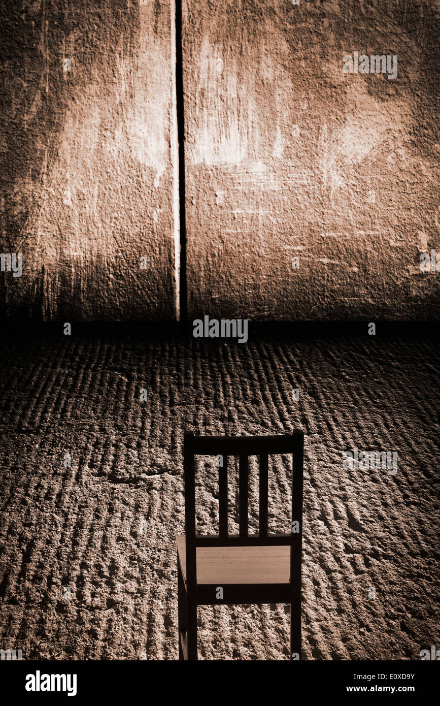 One empty chair in an abandoned room with concrete wall and rough ...