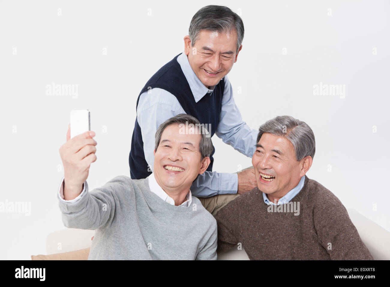 three old men taking a picture on a couch Stock Photo - Alamy