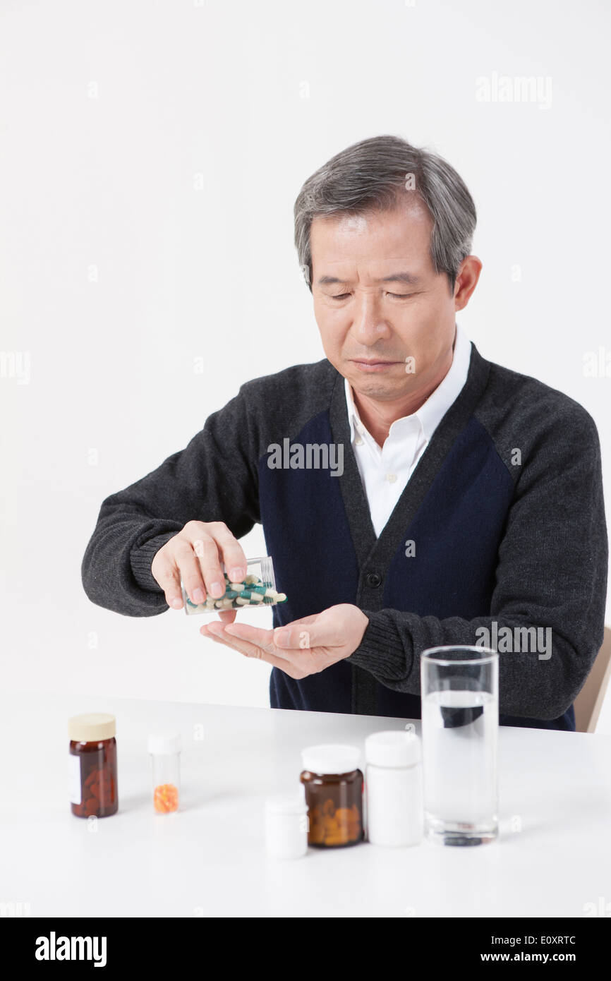 an old man taking medicine Stock Photo - Alamy