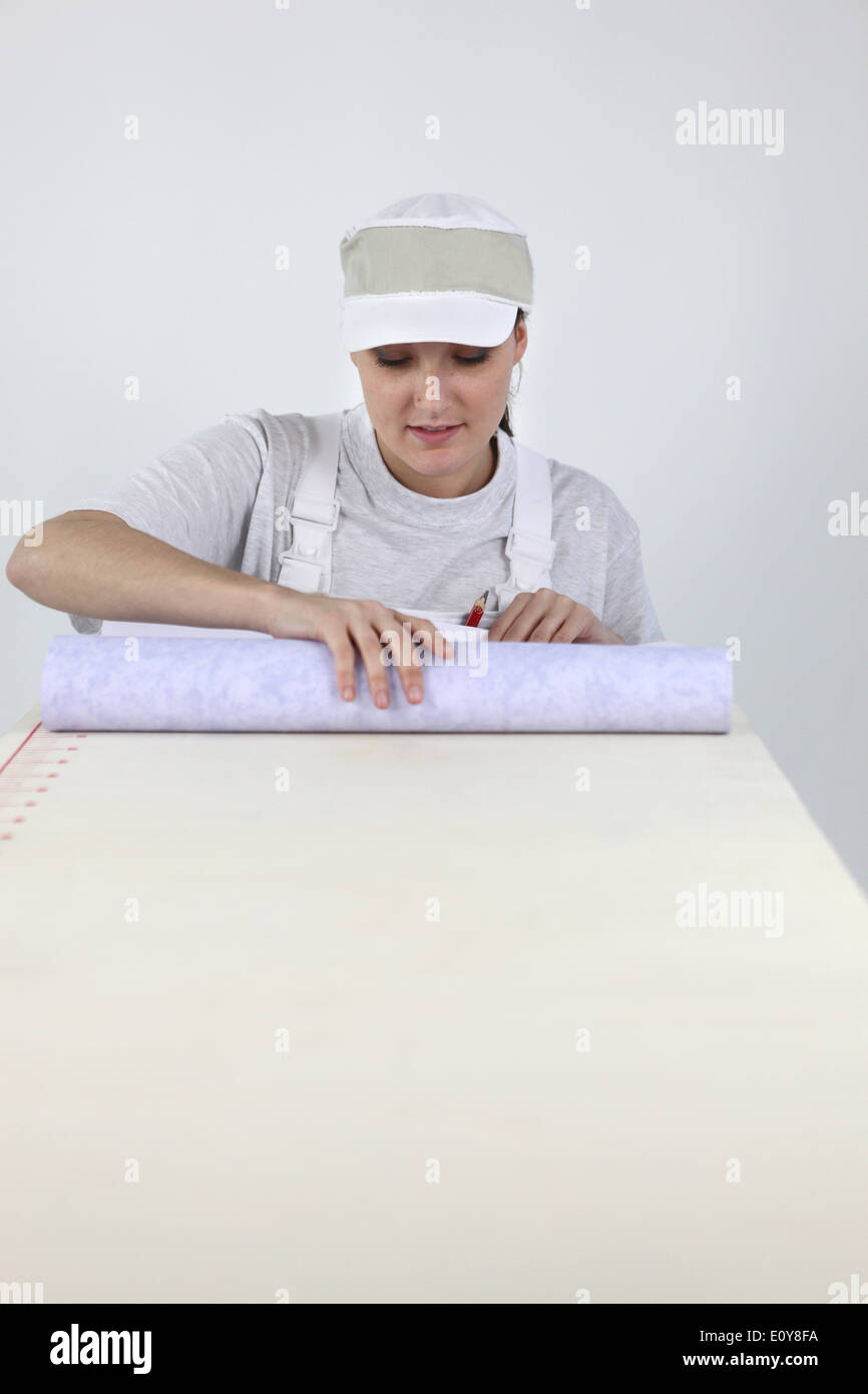 Woman rolling out wallpaper Stock Photo - Alamy