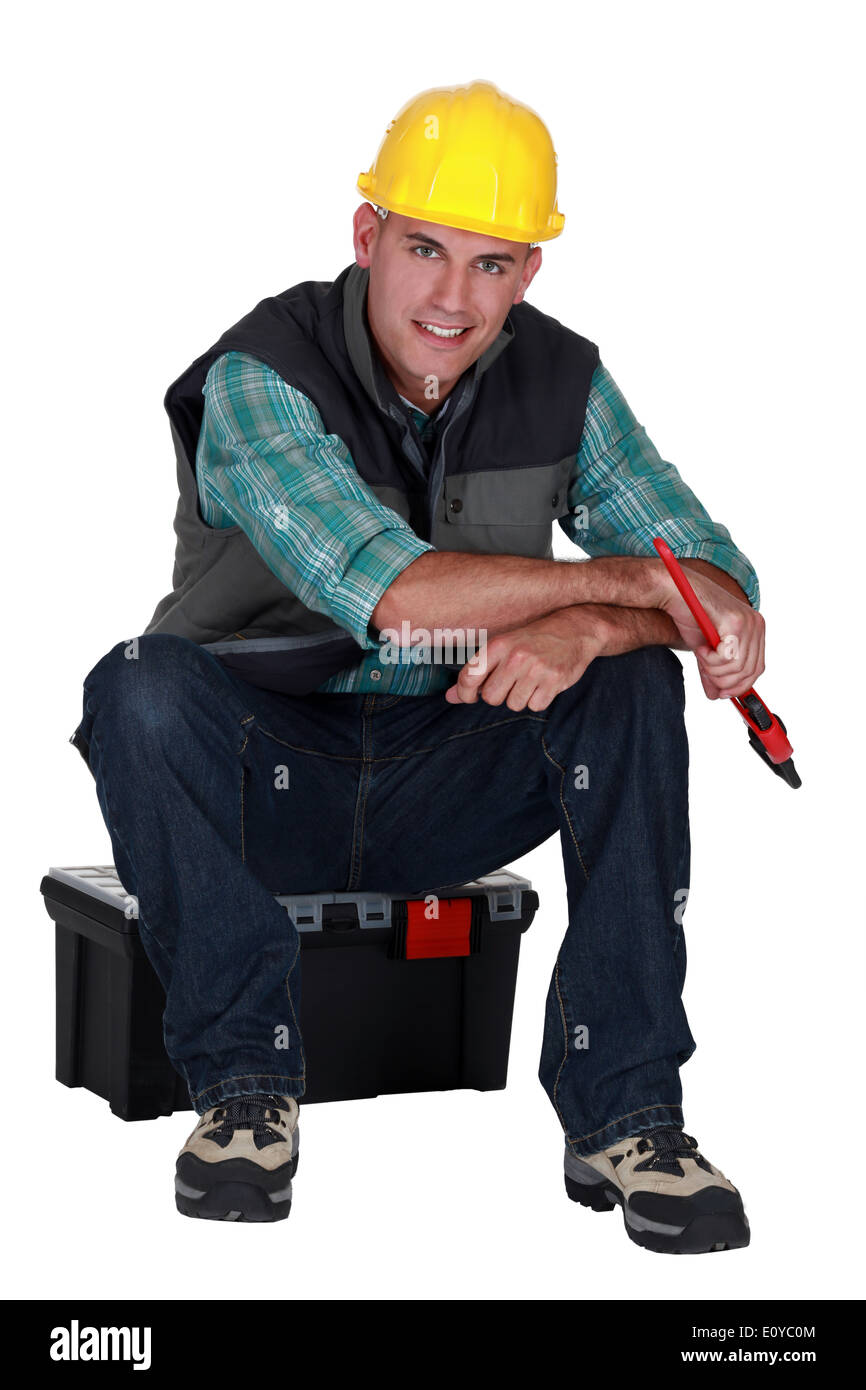 Workman sitting on a toolbox Stock Photo - Alamy