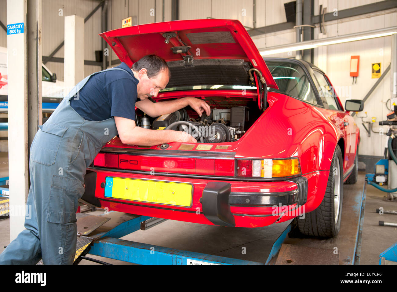 mechanic repairing an older German sports car Stock Photo - Alamy