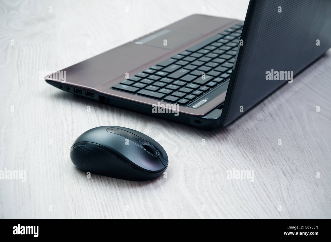 Modern laptop and mouse on light wooden desk Stock Photo - Alamy