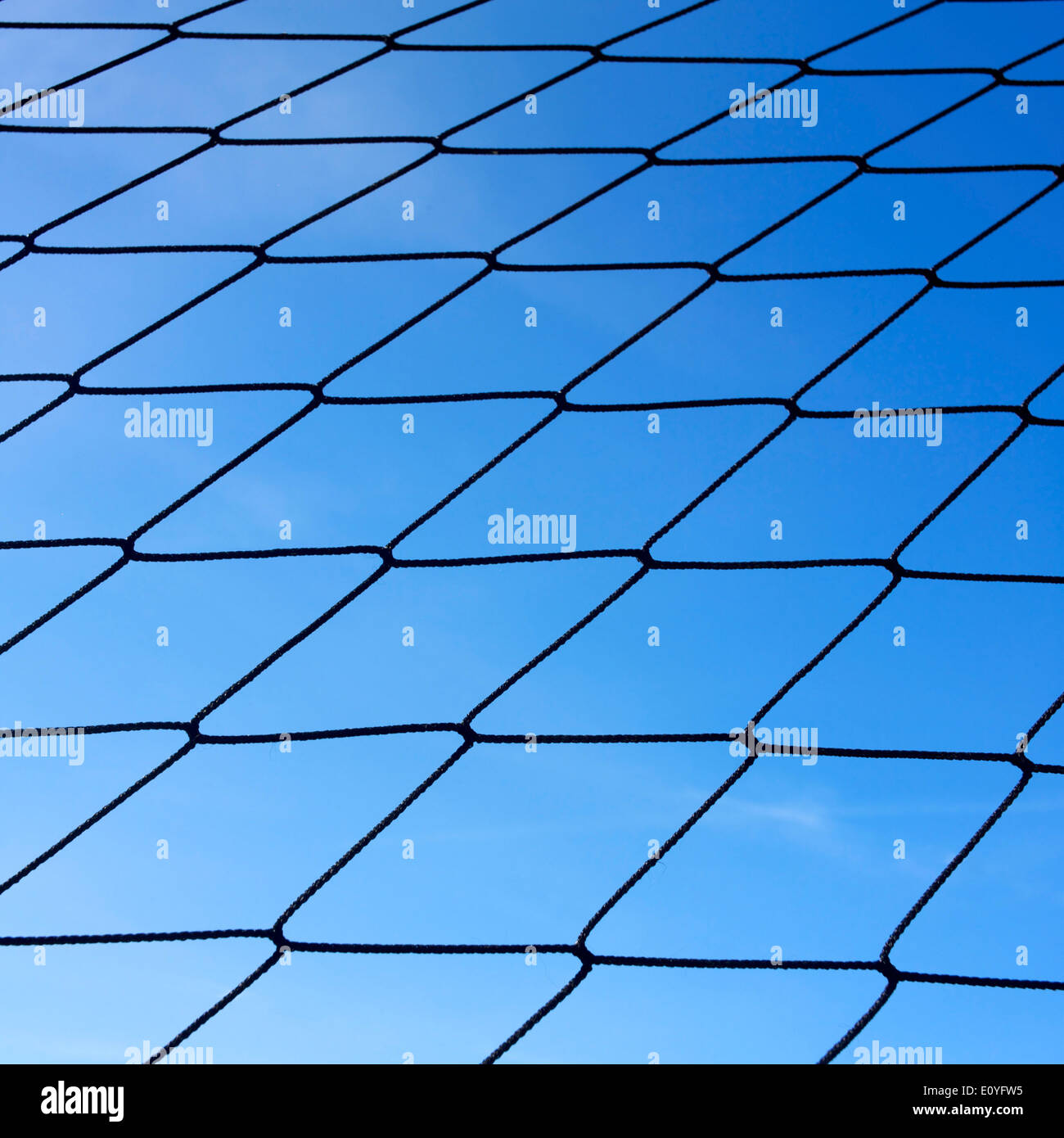 Net structure against clear blue sky creates patterns and textures in a ...