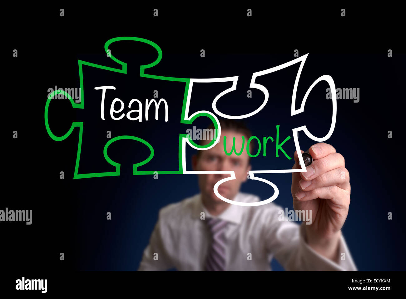 A Businessman drawing a Teamwork puzzle concept Stock Photo - Alamy
