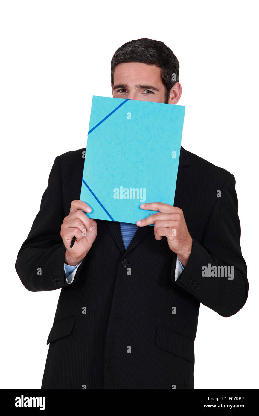 Smiling man hiding behind a folder Stock Photo - Alamy