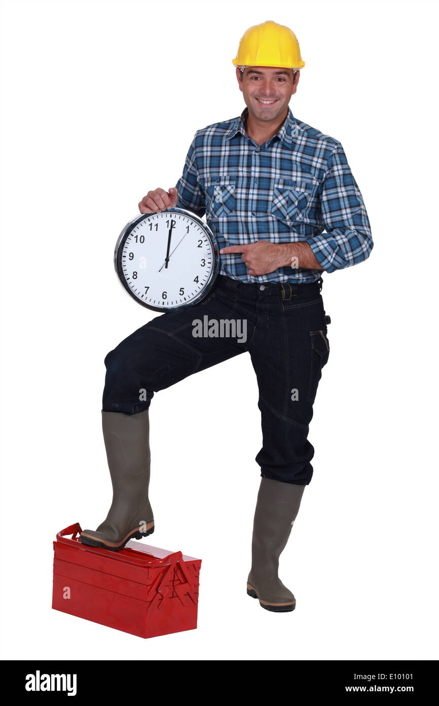 Manual worker pointing to clock Stock Photo - Alamy