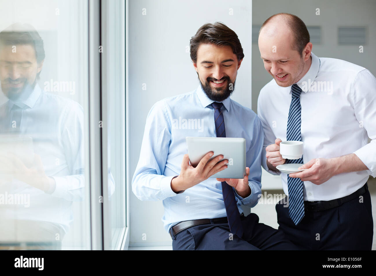 Image of young businessman holding touchpad while explaining idea to ...