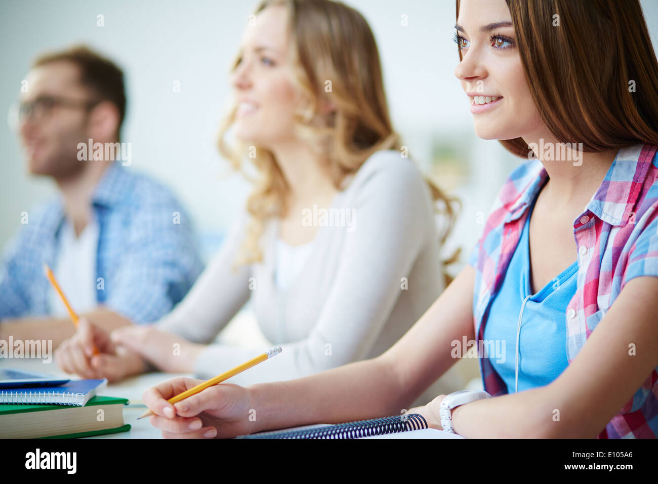 Smart girl listening to teacher at seminar with her groupmates on ...