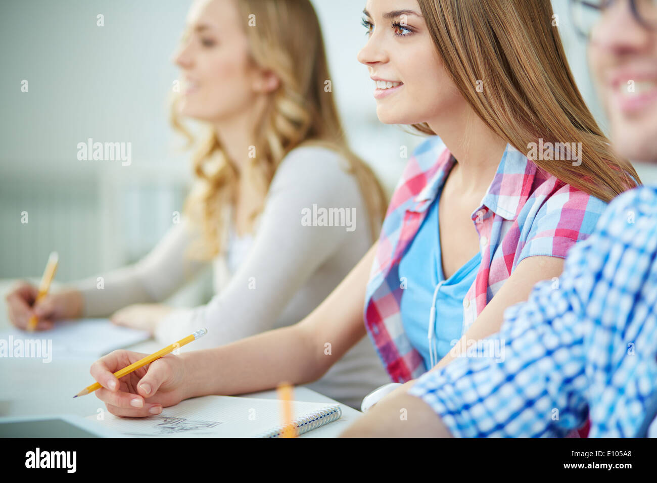 Smart girl listening to teacher at seminar with her groupmates near by ...