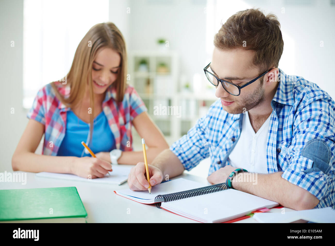 Successful student and his groupmate on background carrying out test at ...