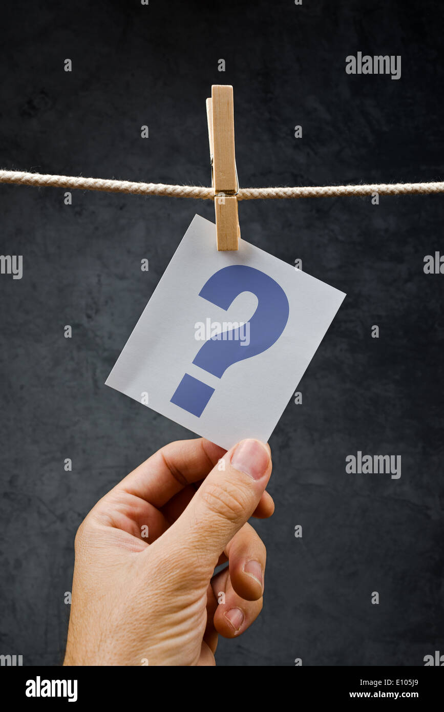 Question mark. Hand picking note paper with printed question mark ...