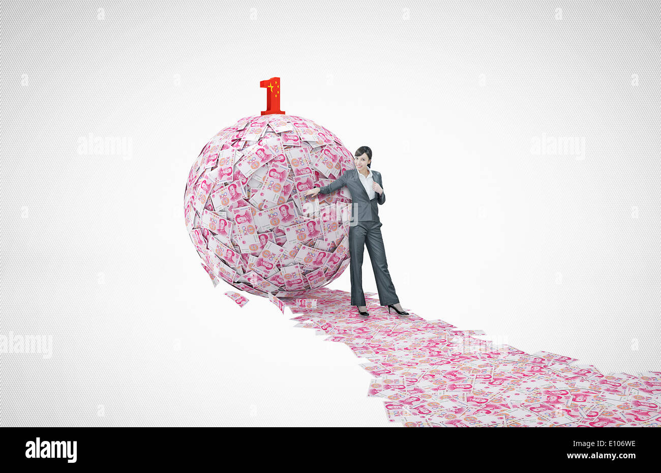 a business woman standing next to a ball of money Stock Photo - Alamy